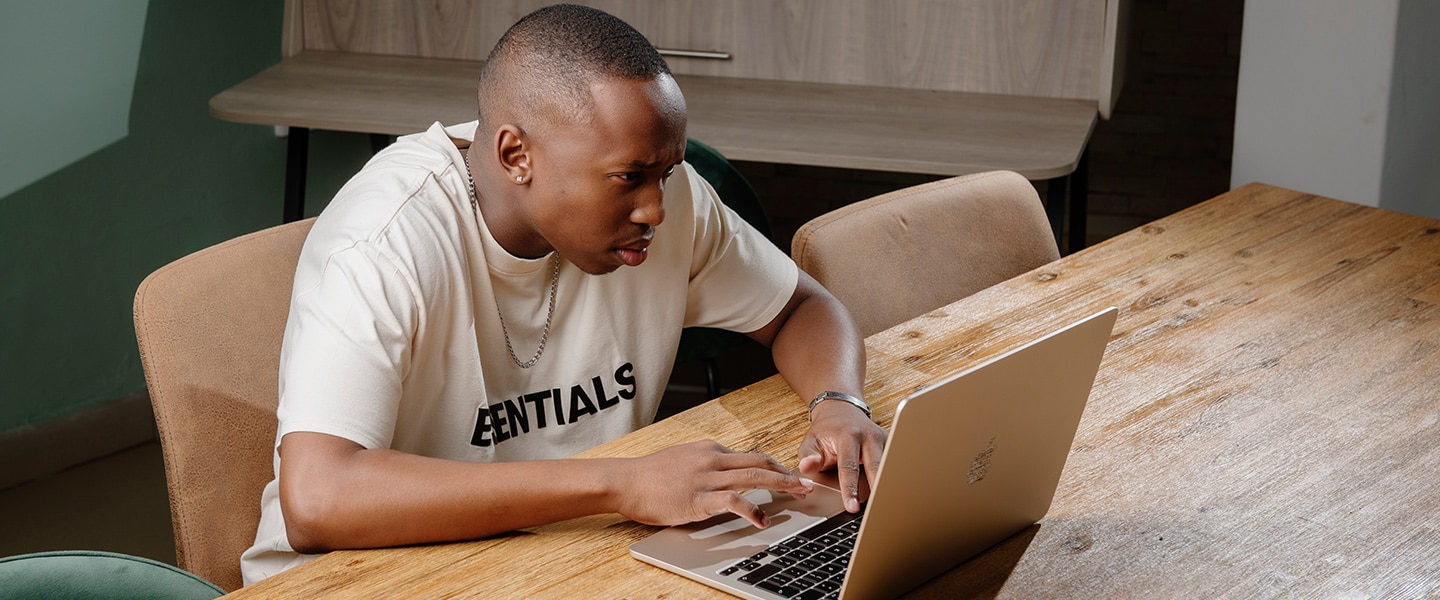 Nathi Msimanga studying at his desk, with books and a laptop in front of him.